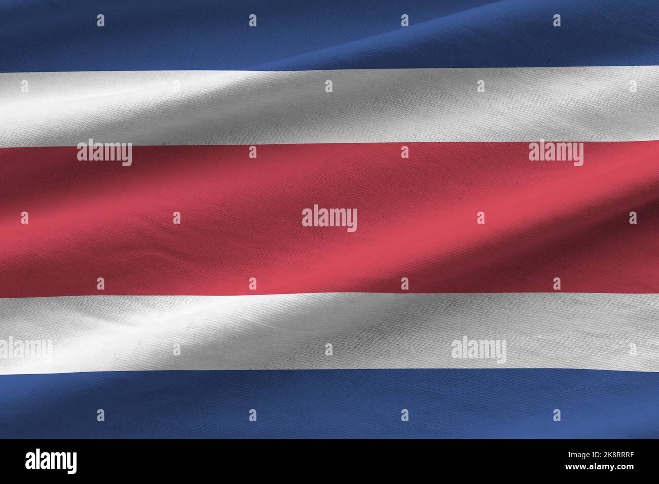 Costa Rica flag with big folds waving close up under the studio light ...