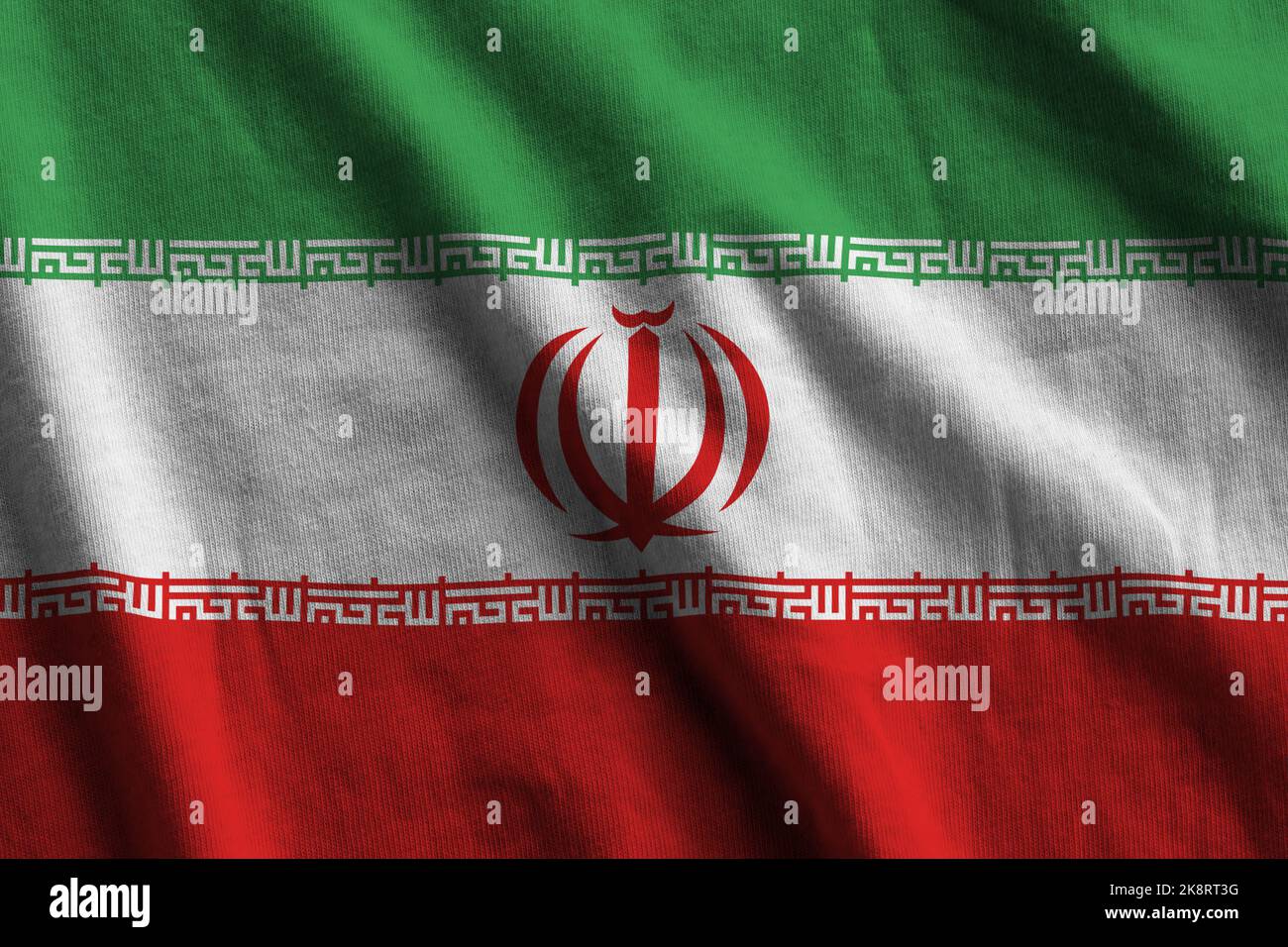 Iran flag with big folds waving close up under the studio light indoors ...