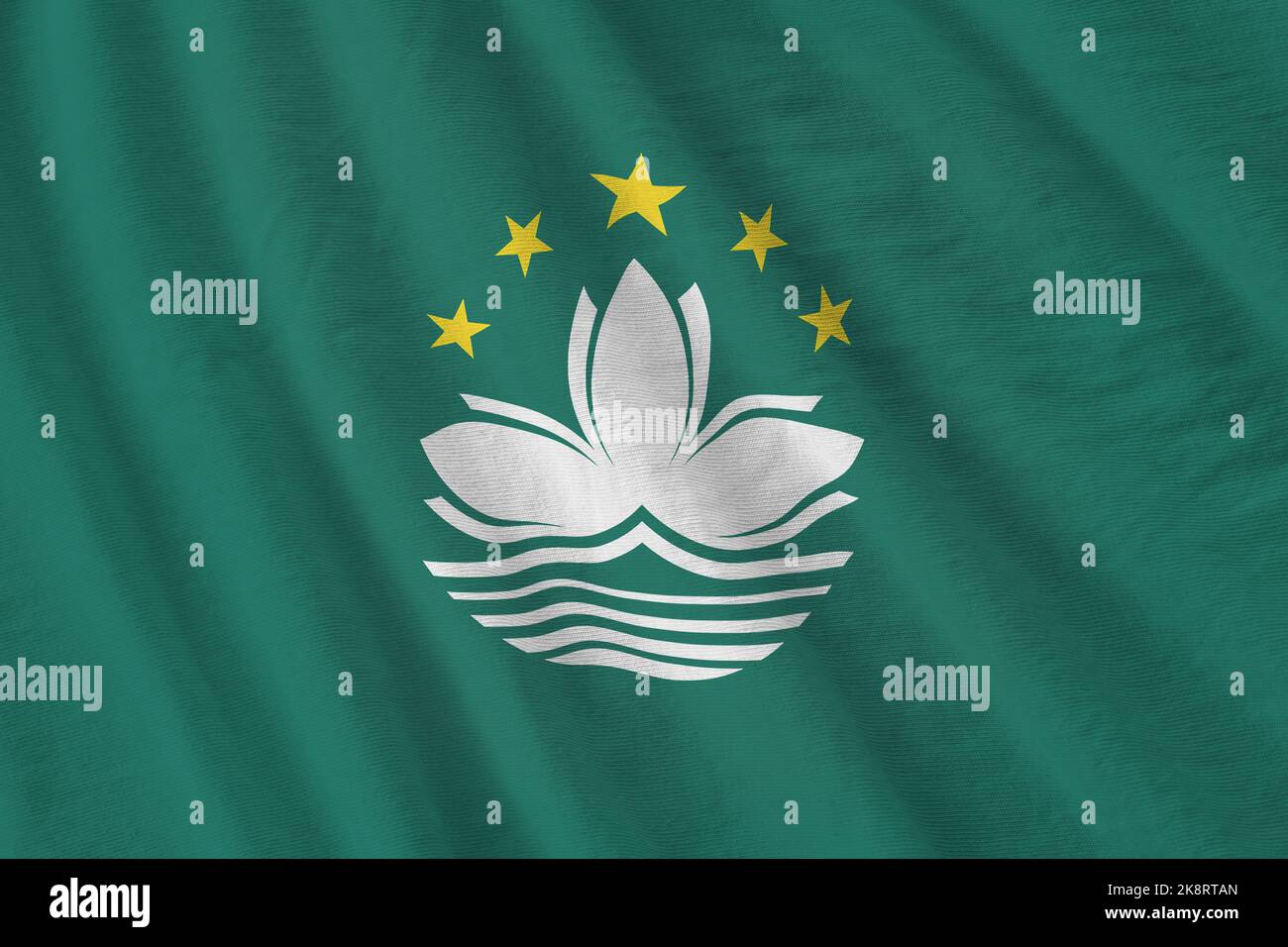 Macau flag with big folds waving close up under the studio light ...