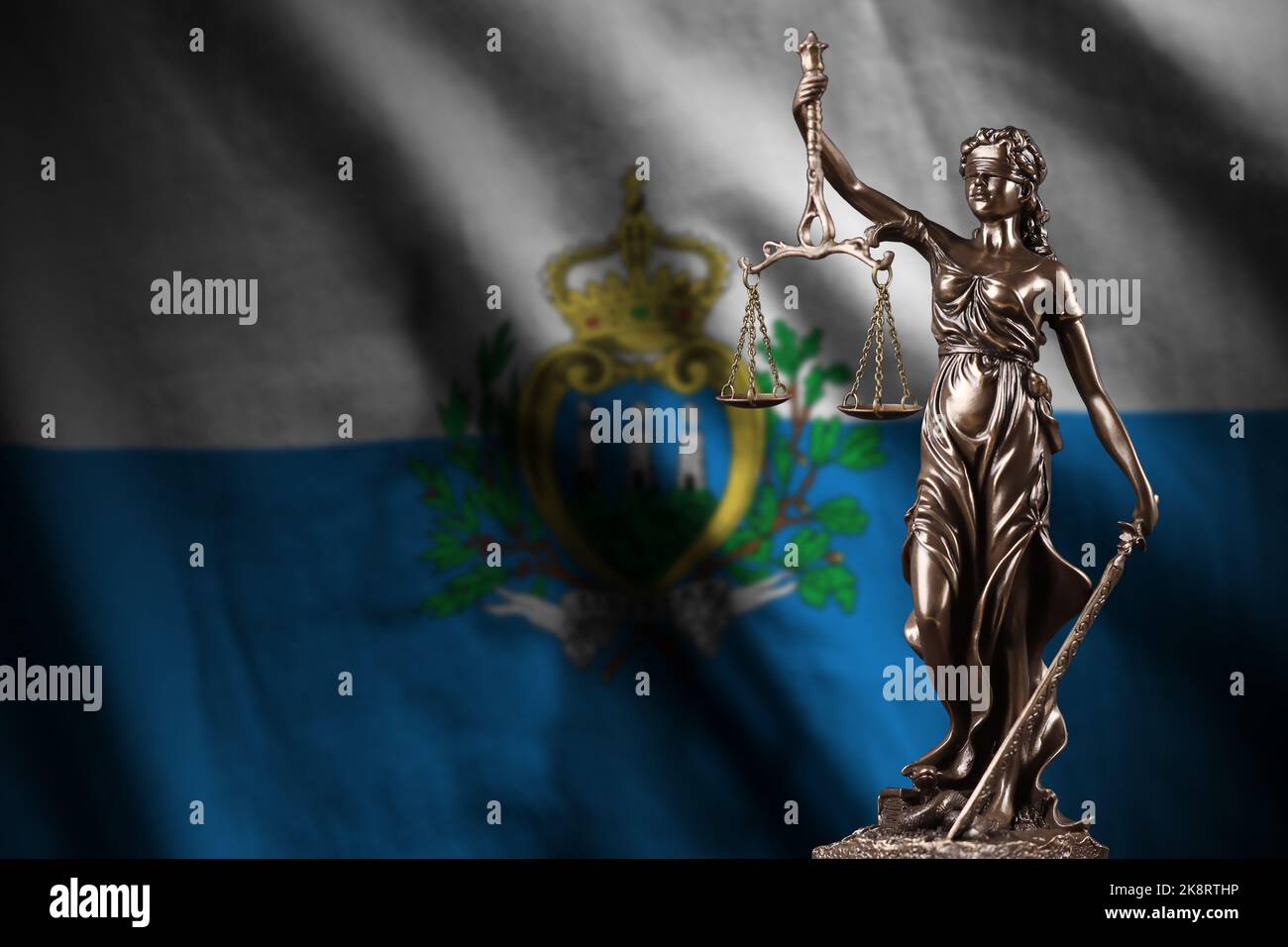 San Marino flag with statue of lady justice and judicial scales in dark ...