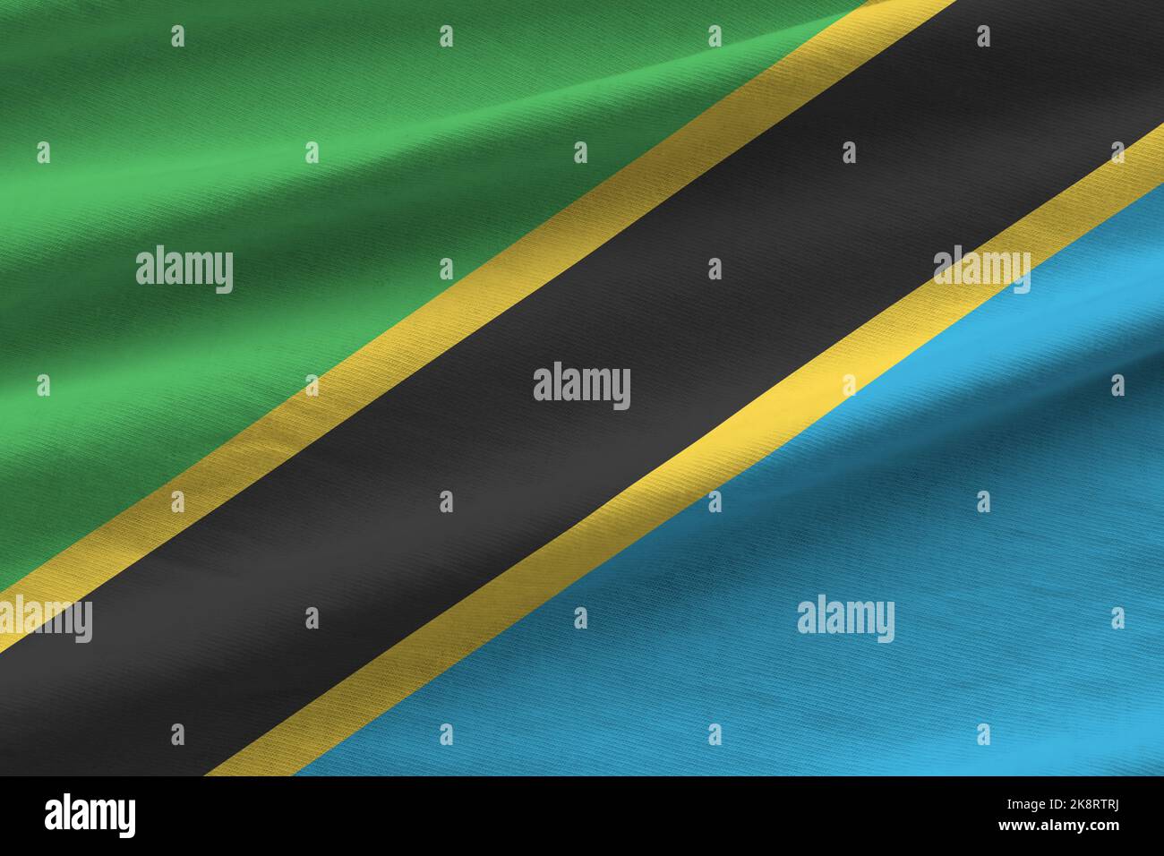 Tanzania flag with big folds waving close up under the studio light ...