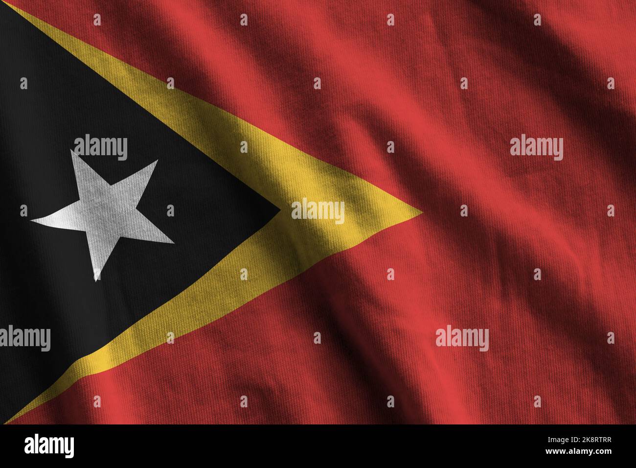 Timor Leste flag with big folds waving close up under the studio light ...