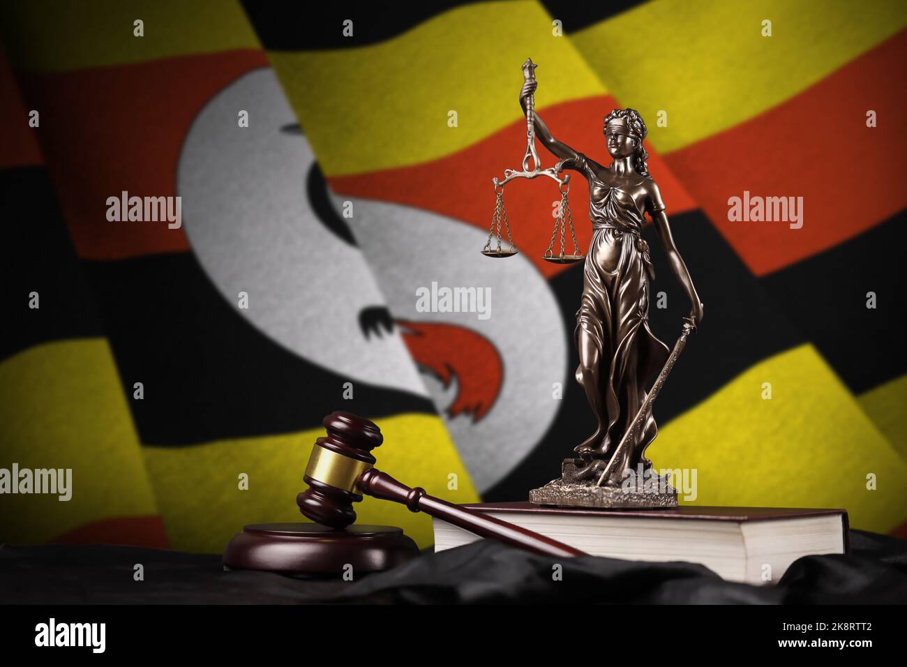 Uganda flag with statue of lady justice, constitution and judge hammer ...