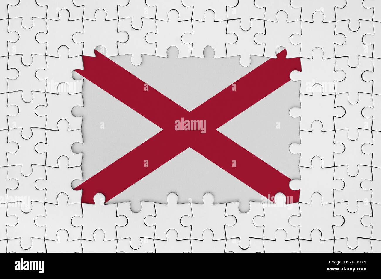 Alabama US state flag in frame of white puzzle pieces with missing ...
