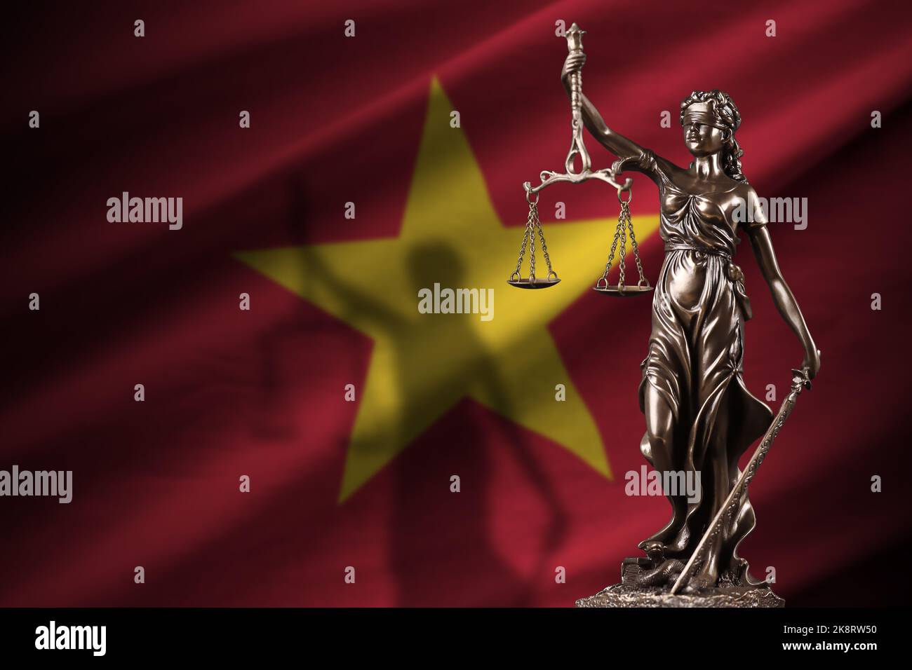 Vietnam flag with statue of lady justice and judicial scales in dark room. Concept of judgement ...