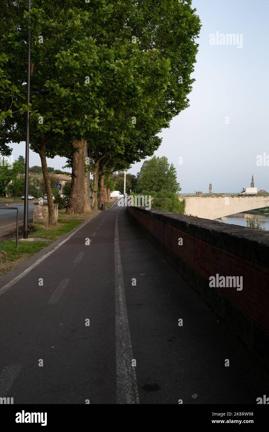 A vertical shot of a bike path along the Arno River in Florence, Italy ...