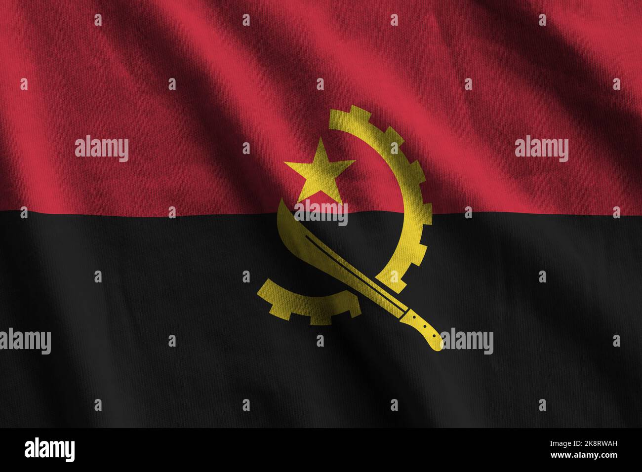 Angola flag with big folds waving close up under the studio light ...