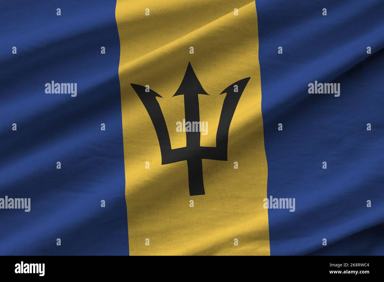 Barbados flag with big folds waving close up under the studio light ...