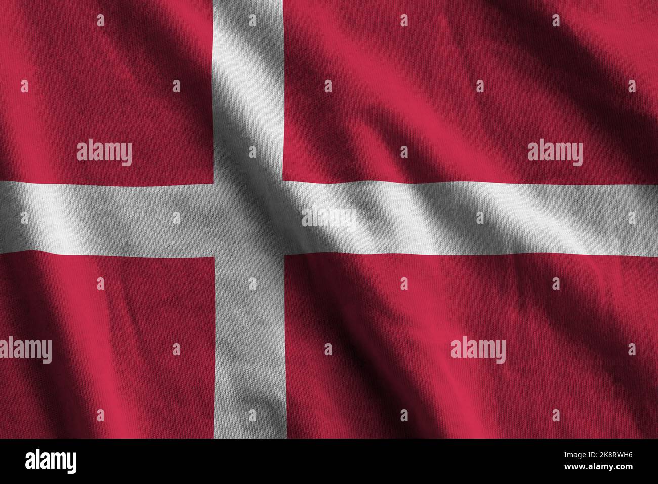 Denmark flag with big folds waving close up under the studio light ...
