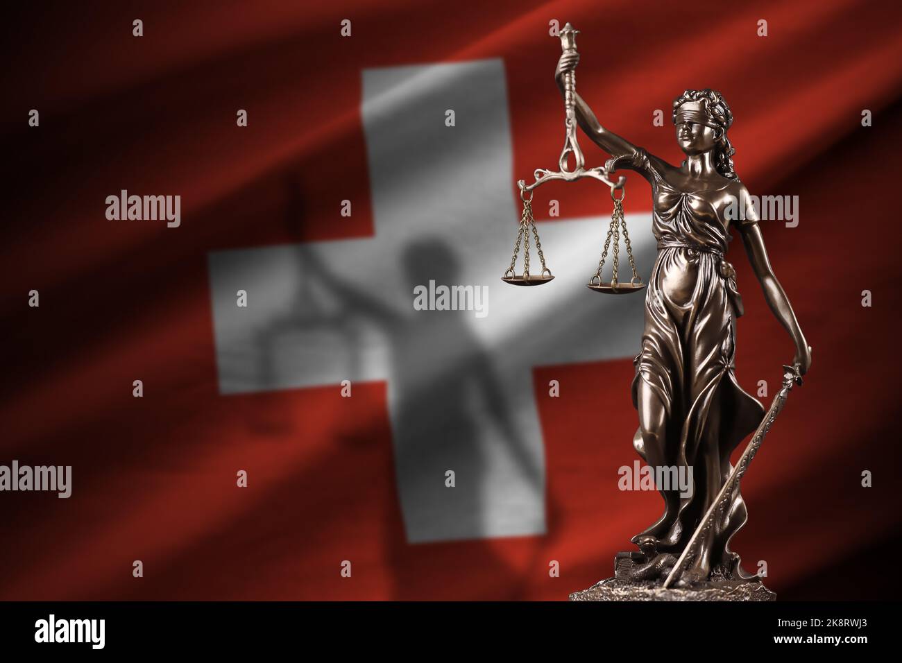 Switzerland flag with statue of lady justice and judicial scales in ...
