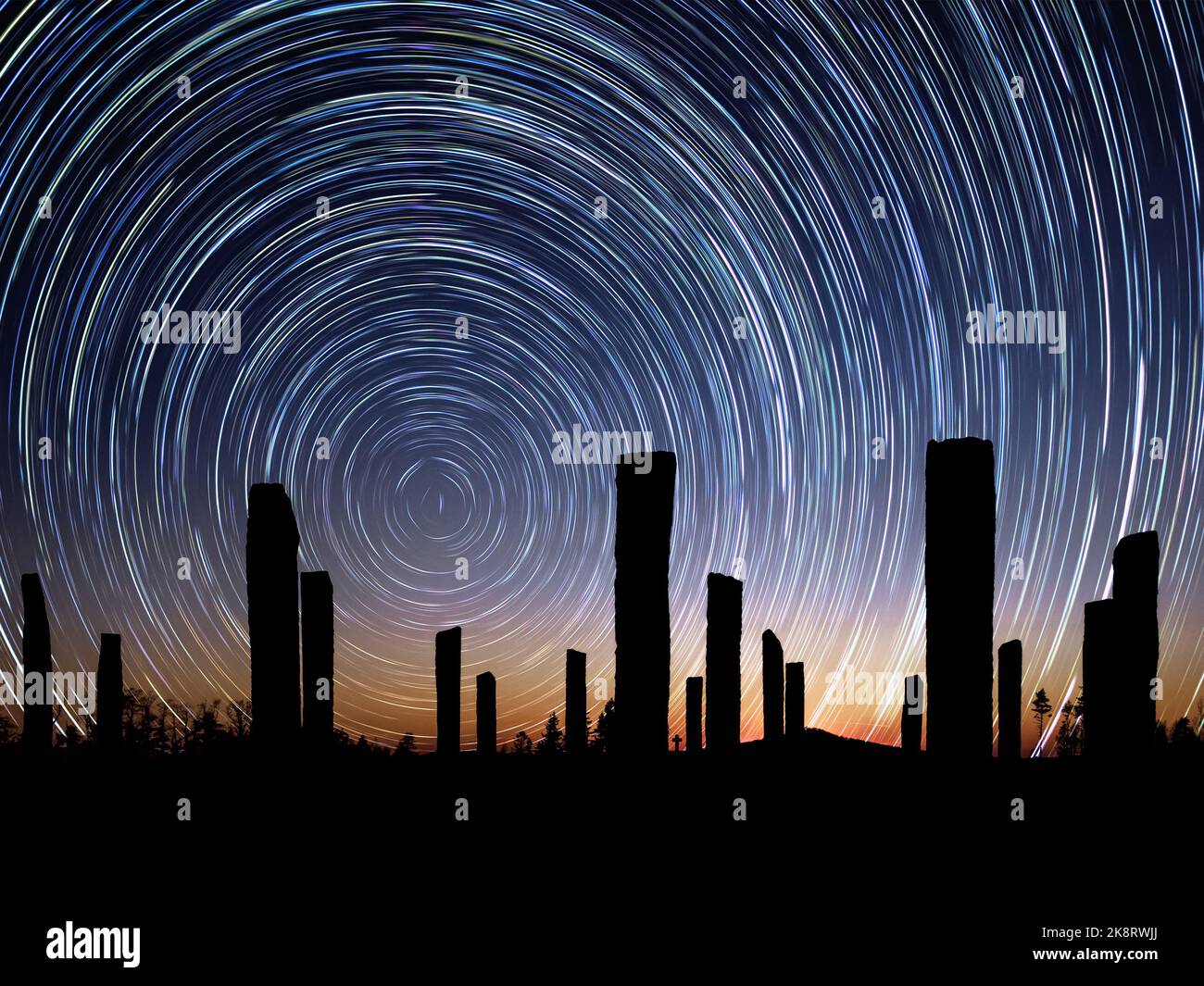 The silhouettes of wooden pillars with circle star trail in blue and ...
