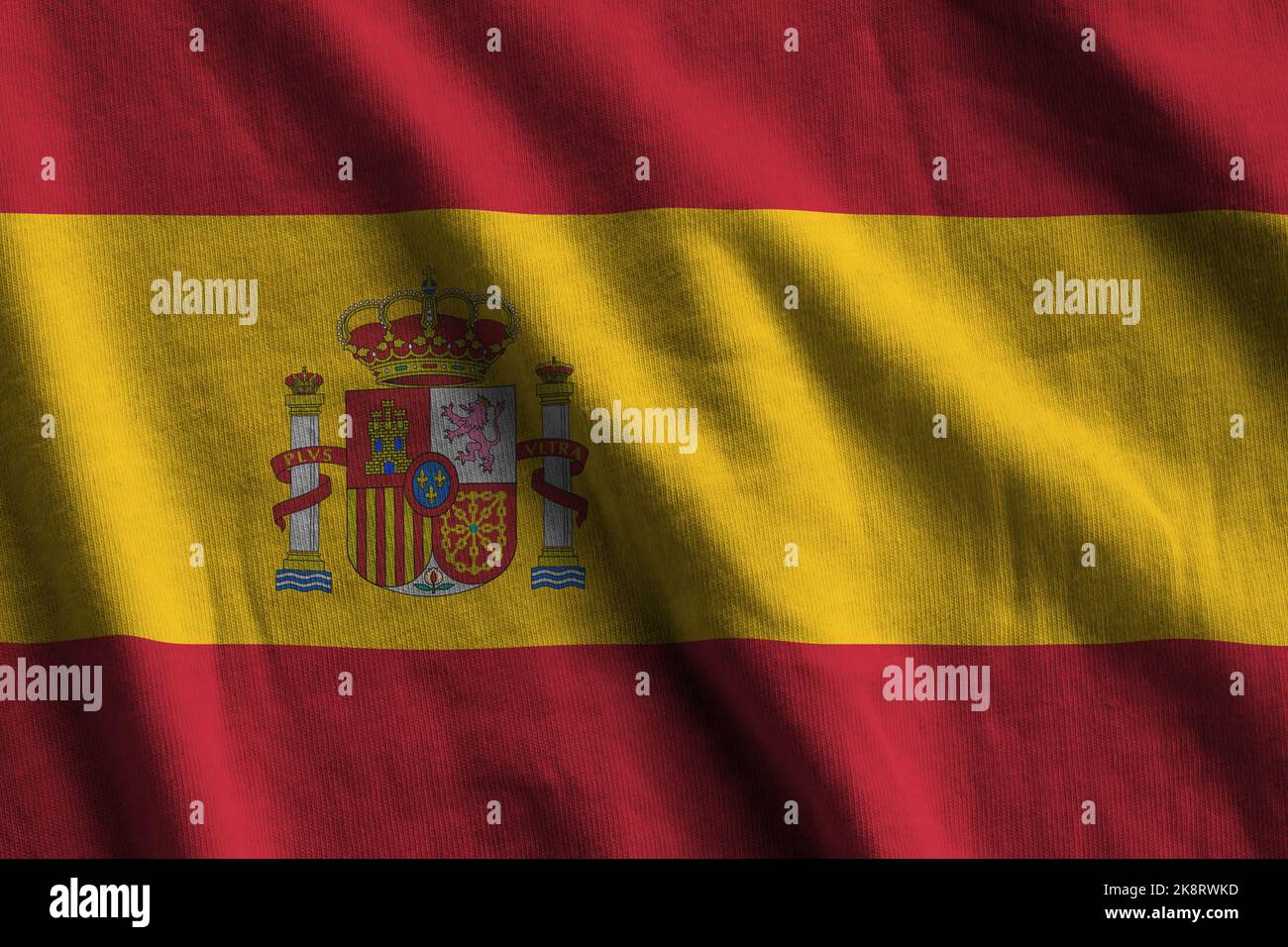 Spain flag with big folds waving close up under the studio light ...