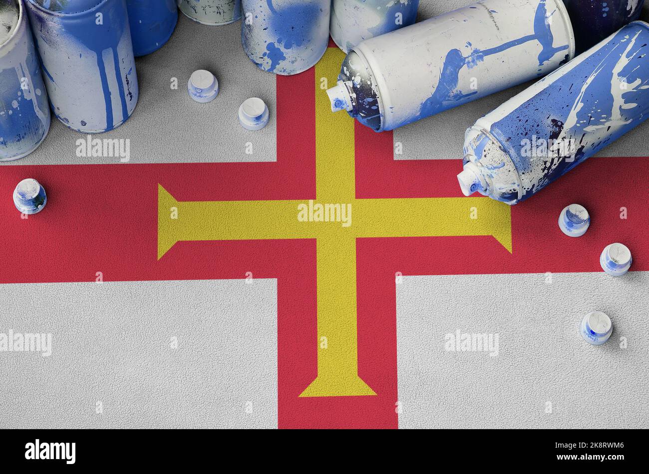 Guernsey flag and few used aerosol spray cans for graffiti painting ...