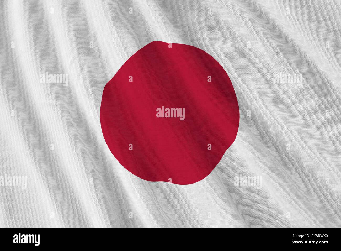 Japan flag with big folds waving close up under the studio light ...