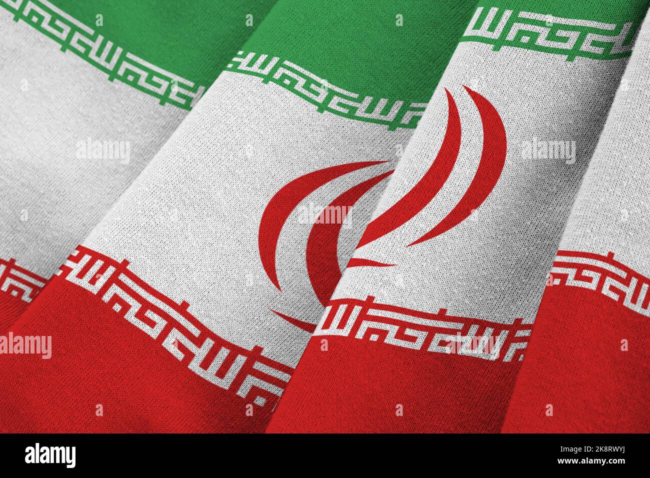 Iran flag with big folds waving close up under the studio light indoors ...