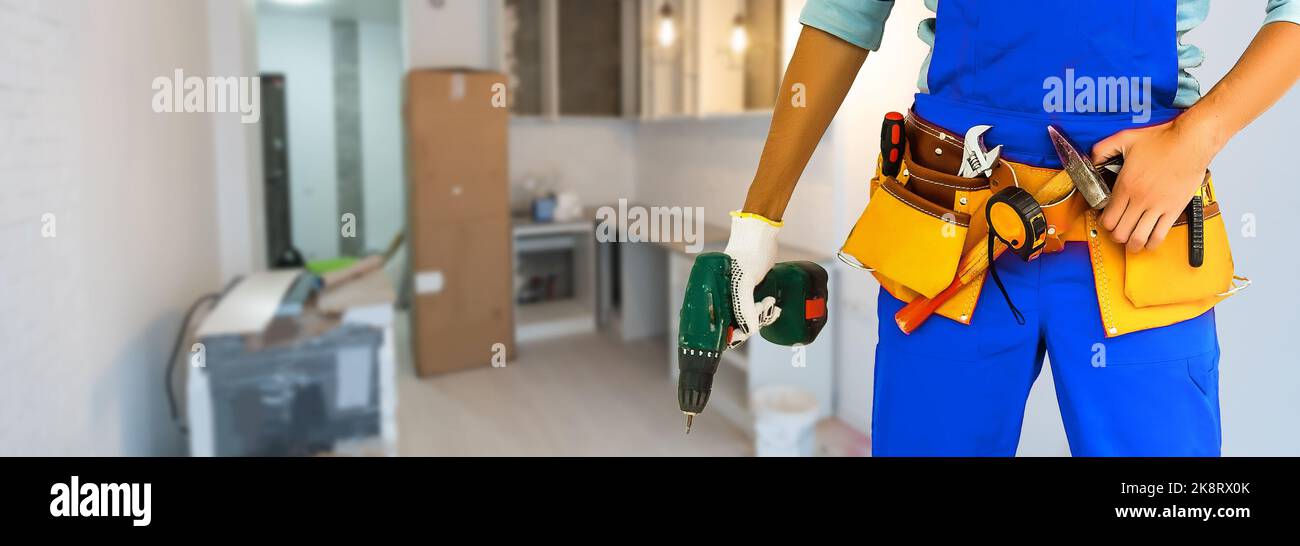 unknown handyman with hands on waist and tool belt with construction ...