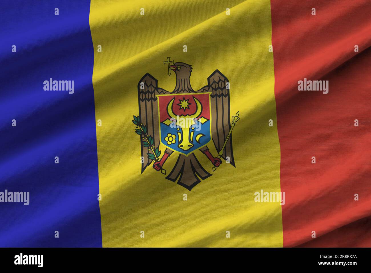 Moldova flag with big folds waving close up under the studio light ...