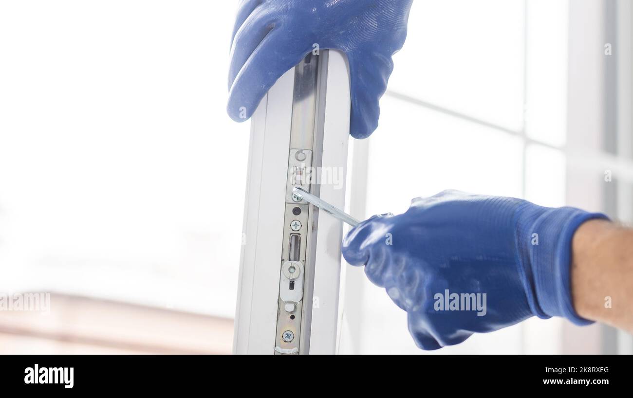installation of plastic in a frame house, the builder screws the window ...
