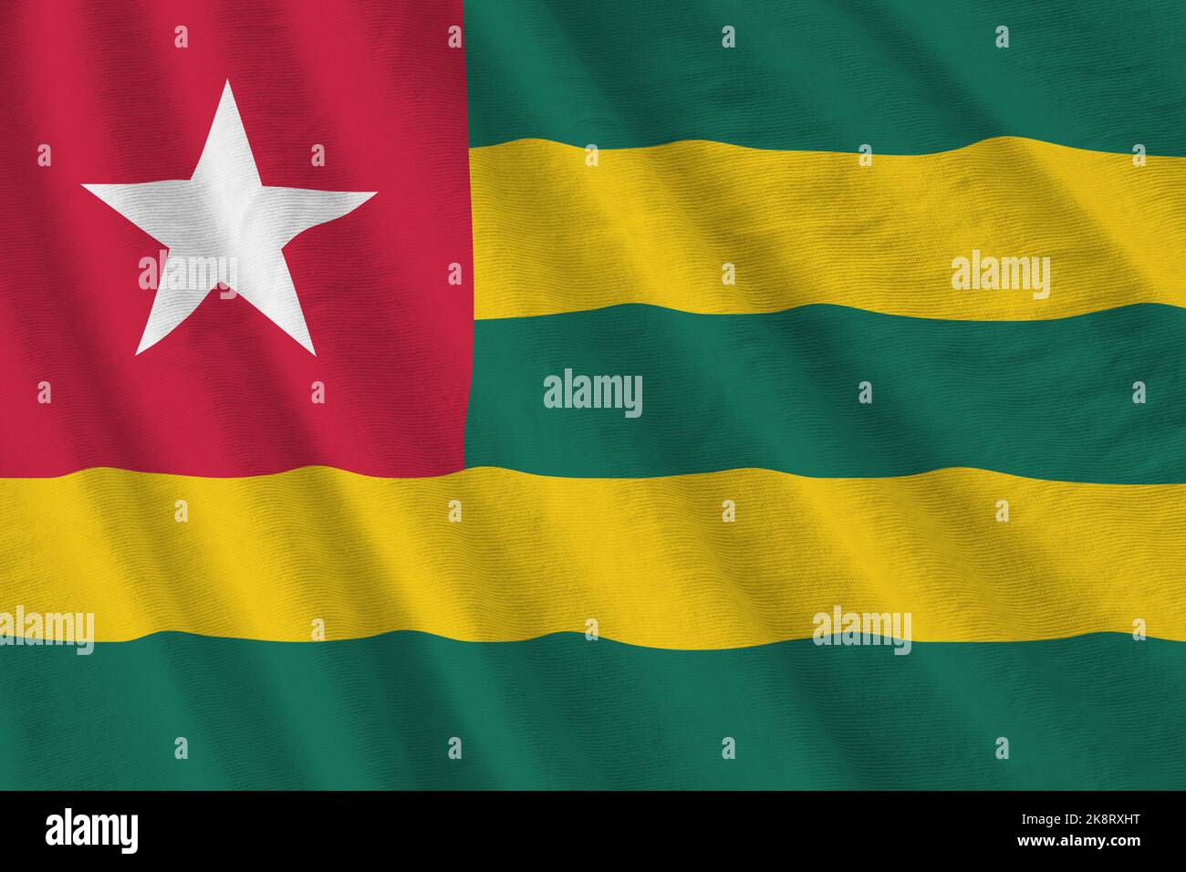 Togo flag with big folds waving close up under the studio light indoors ...
