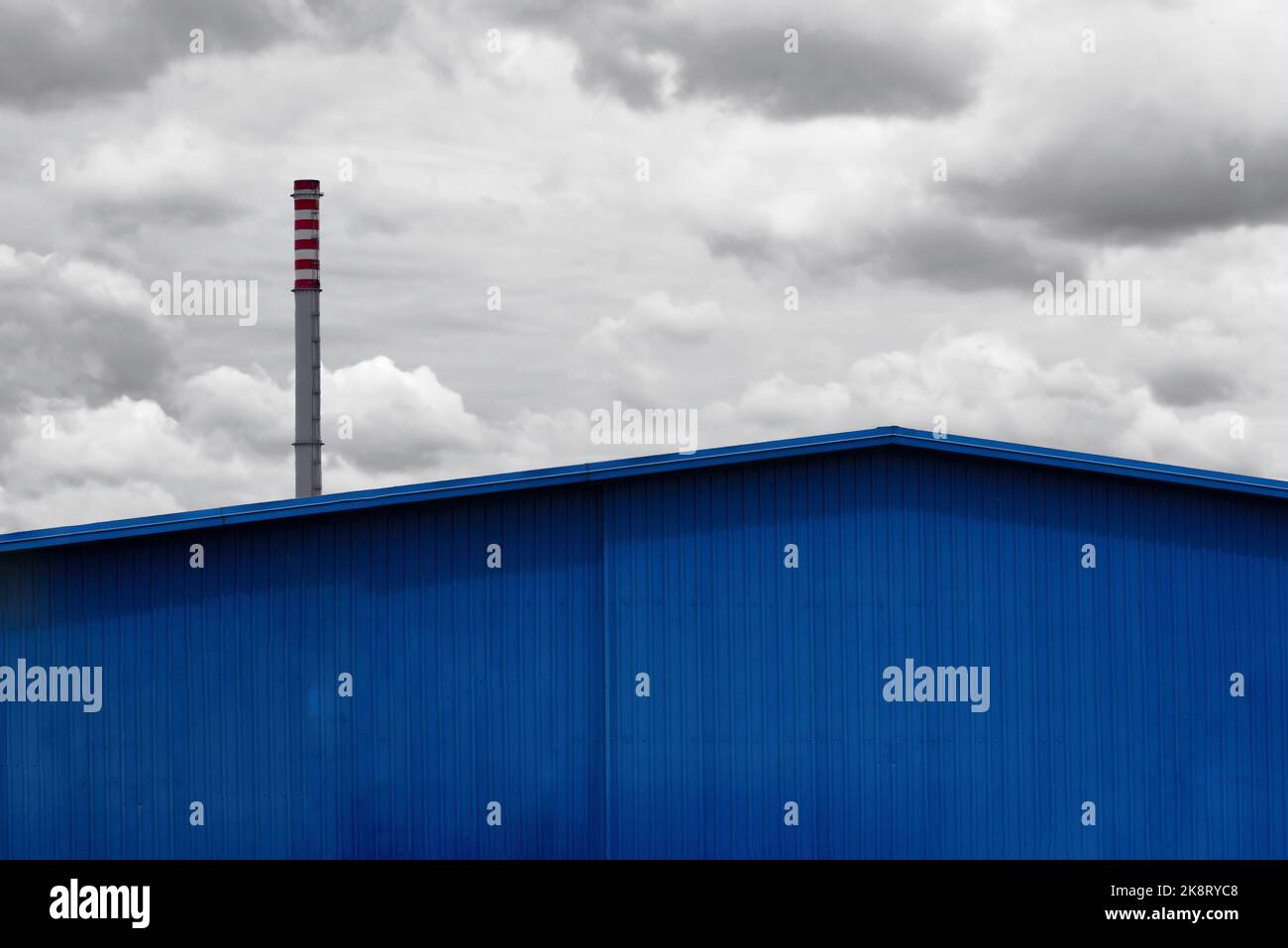 A blue bodega building with a dark clouds above Stock Photo - Alamy