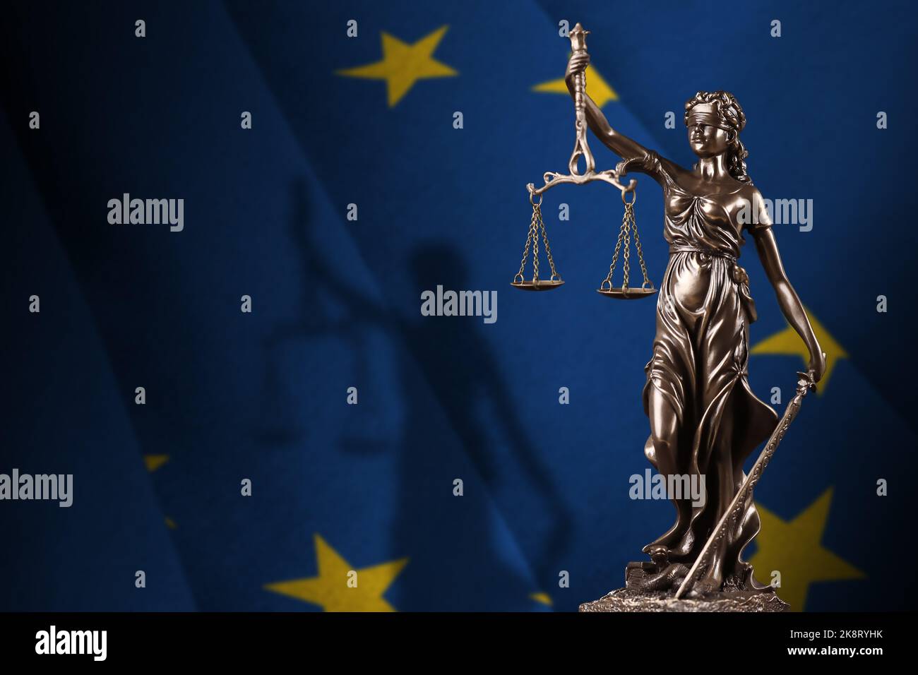 European union flag with statue of lady justice and judicial scales in ...
