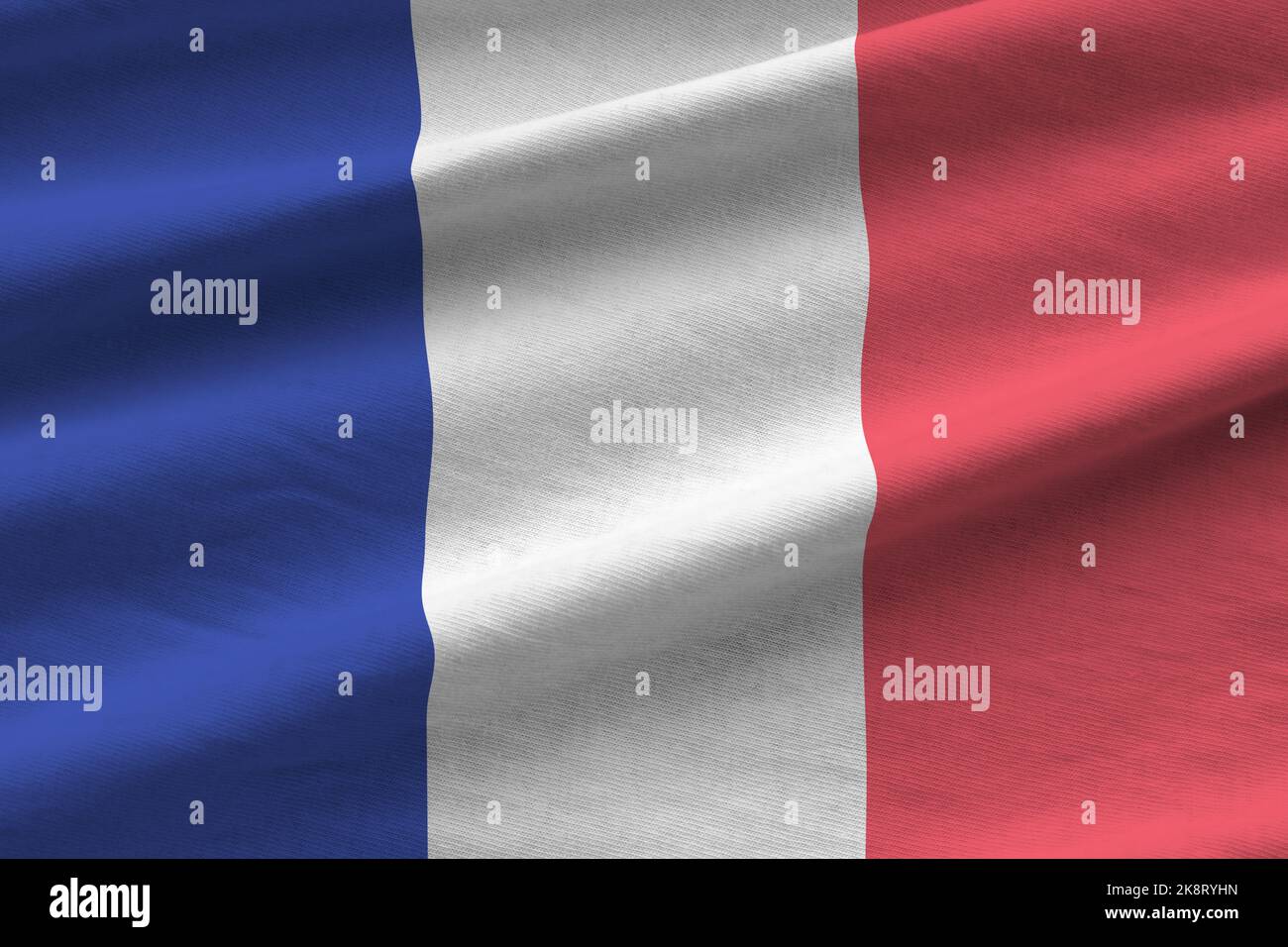 France flag with big folds waving close up under the studio light ...