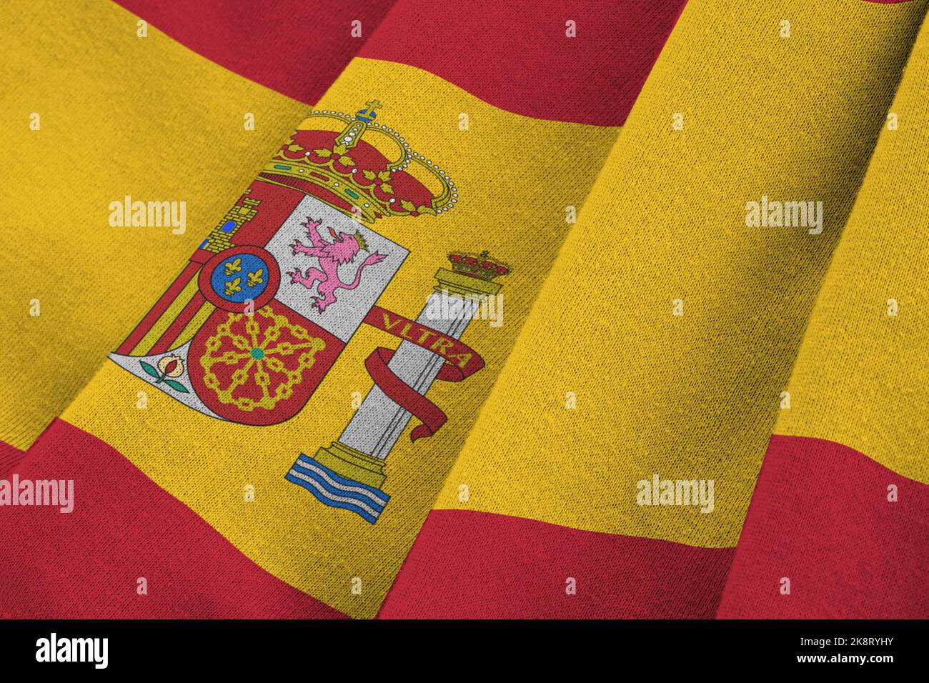 Spain flag with big folds waving close up under the studio light ...