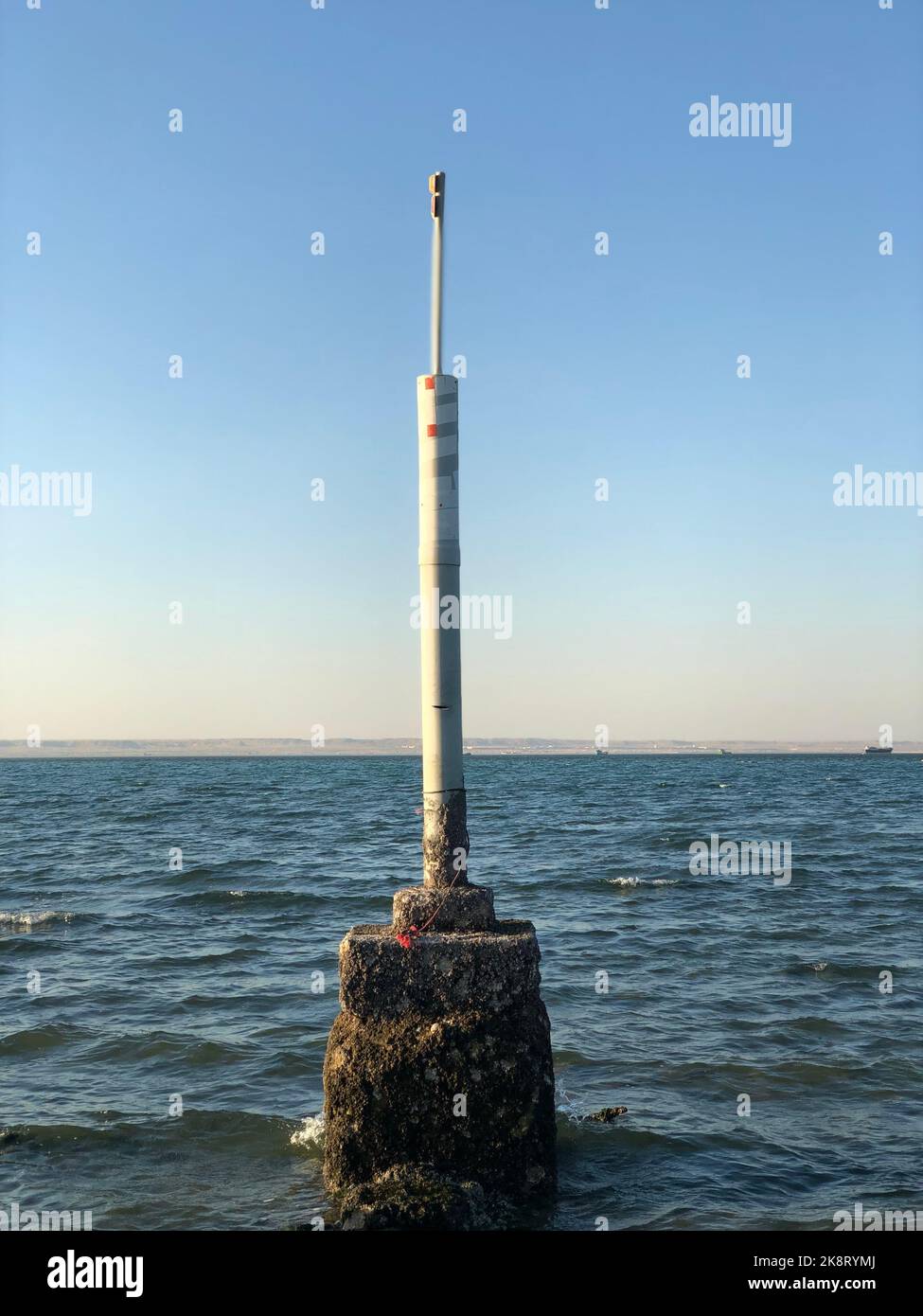 A vertical shot of large signal buoy in the seawater under the clear ...