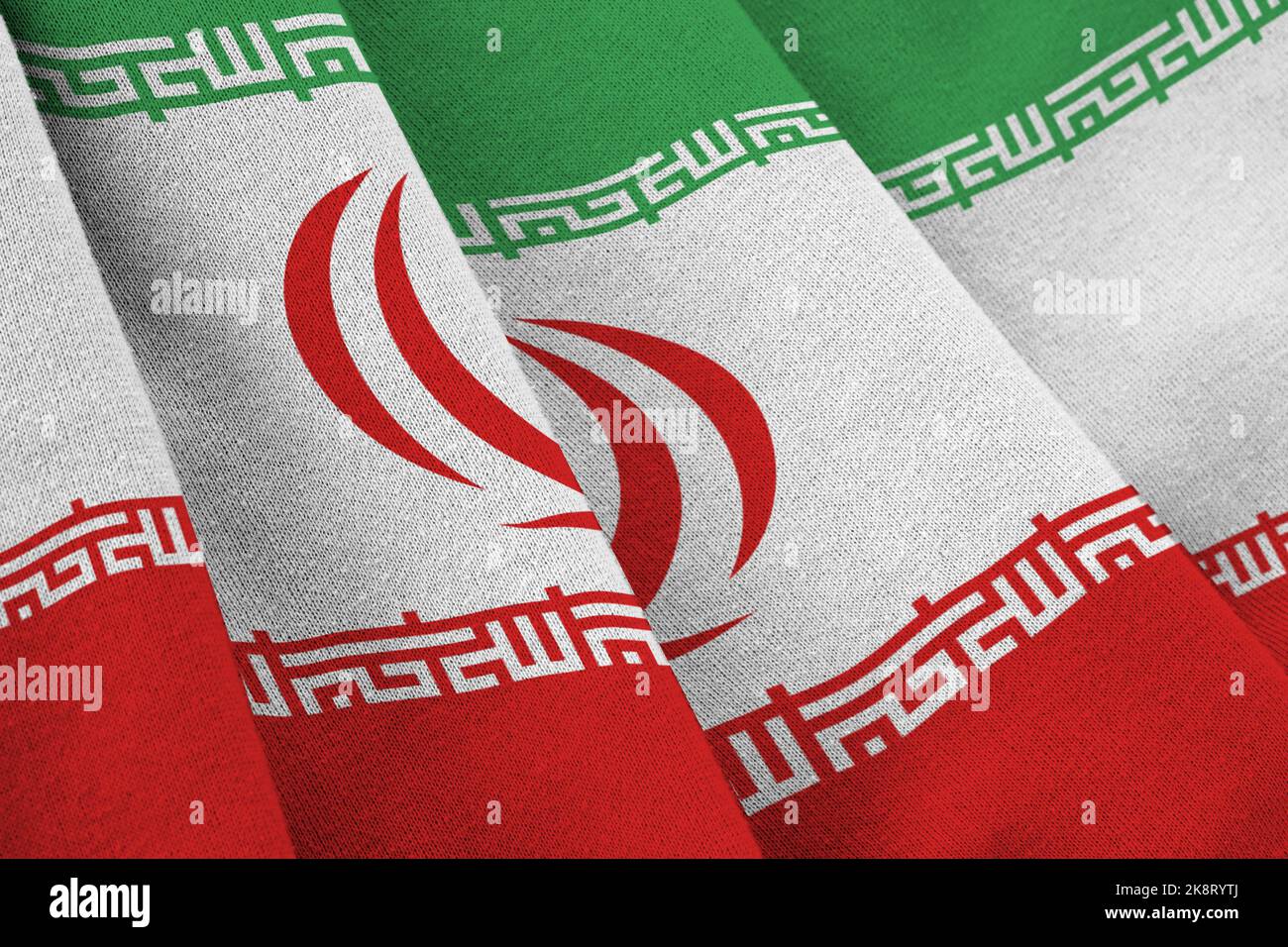 Iran flag with big folds waving close up under the studio light indoors ...