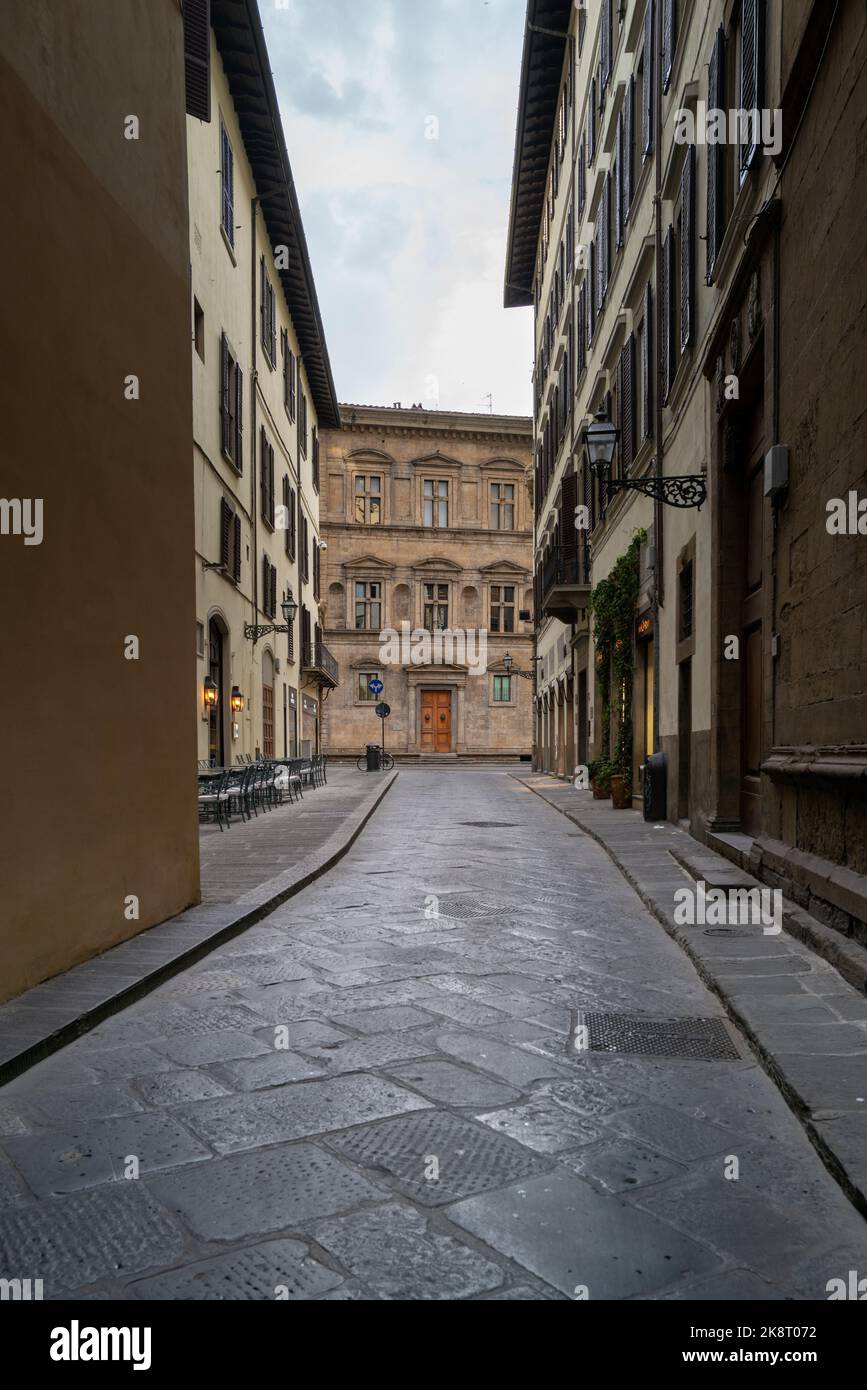 A vertical shot of an old narrow street with high buildings, Florence ...
