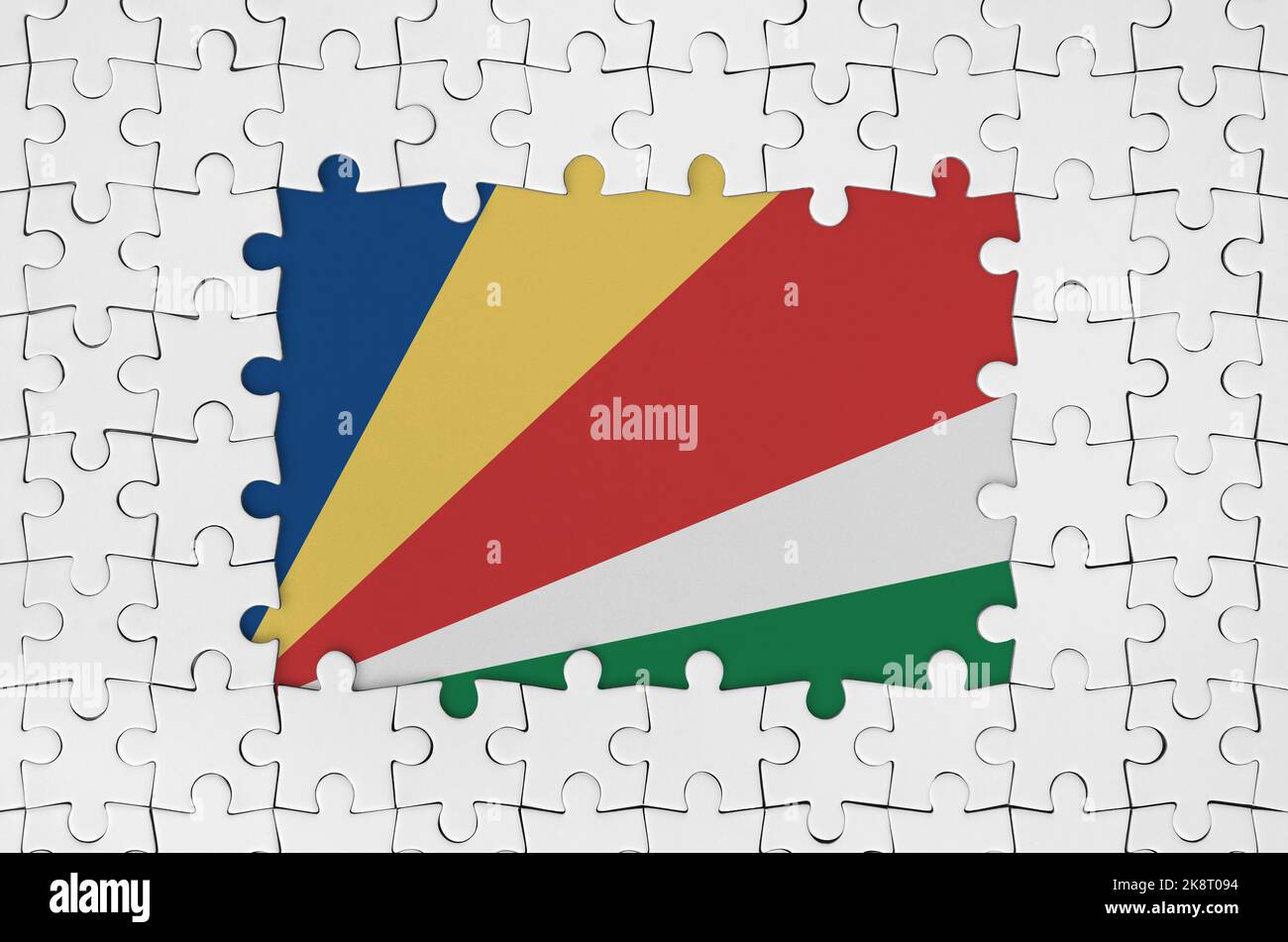 Seychelles flag in frame of white puzzle pieces with missing central ...