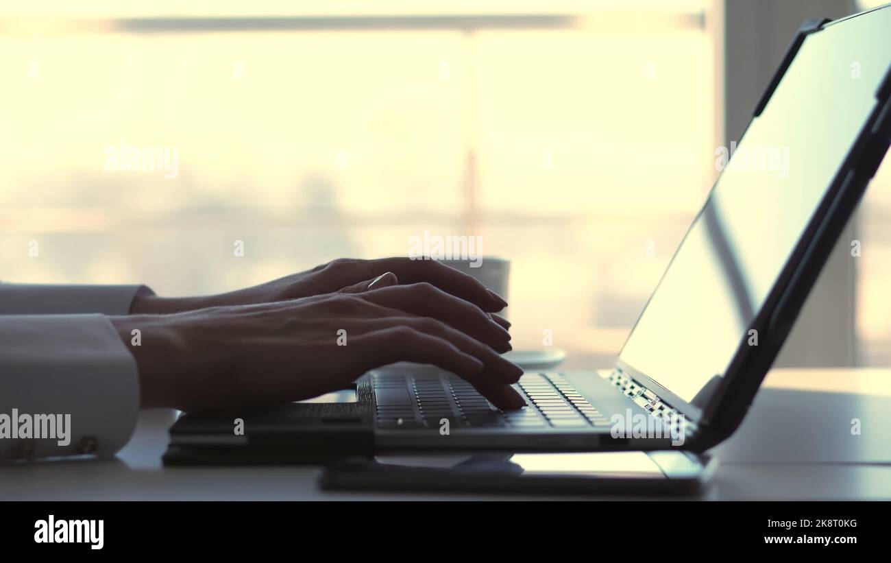 close-up, female hands typing something on a laptop keyboard. At the ...