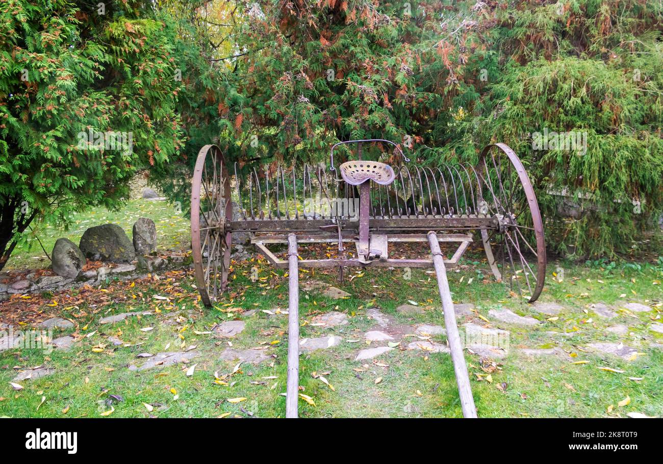 An old horse rake lies on the grass on an autumn day Stock Photo - Alamy