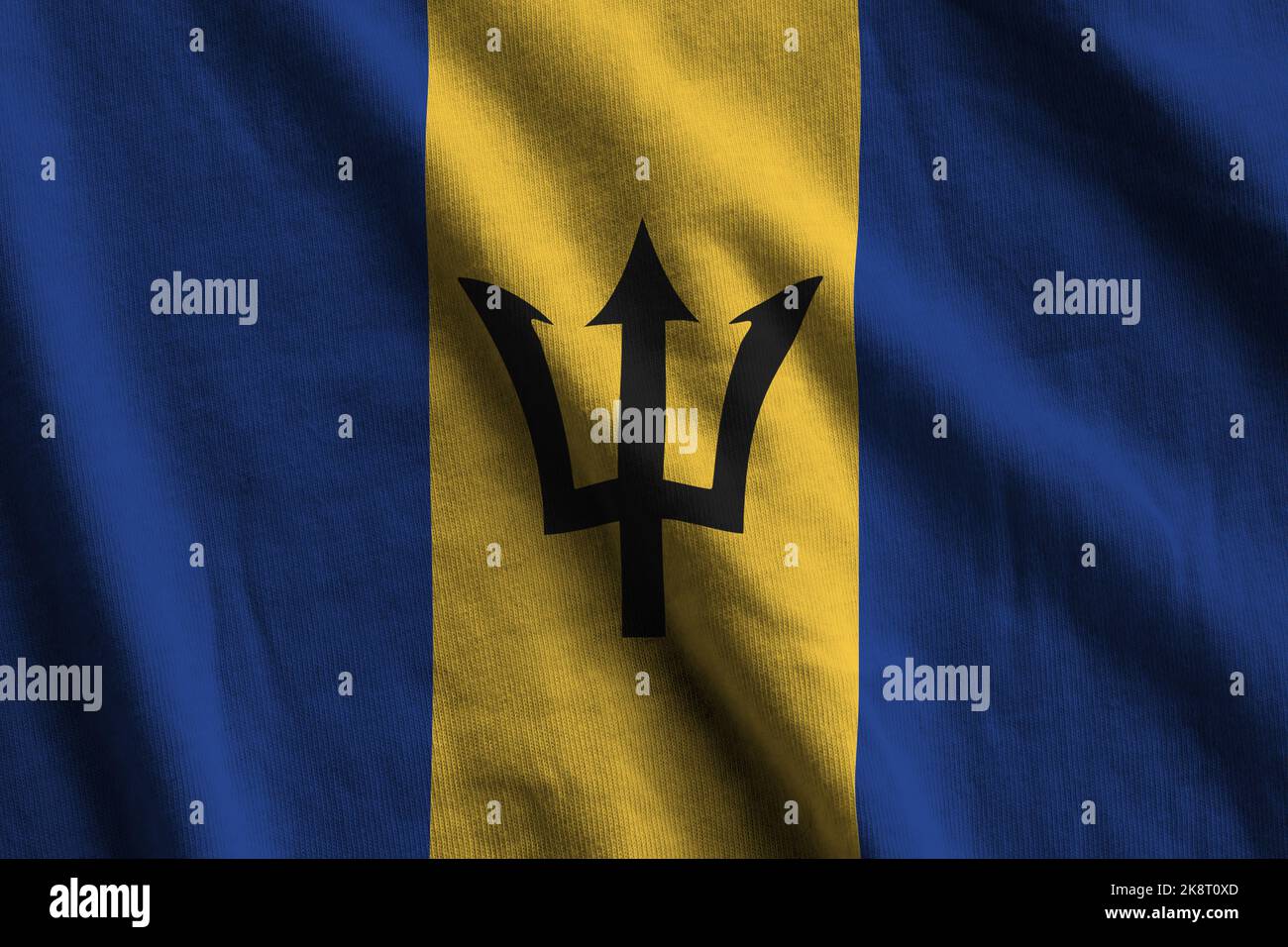 Barbados flag with big folds waving close up under the studio light ...
