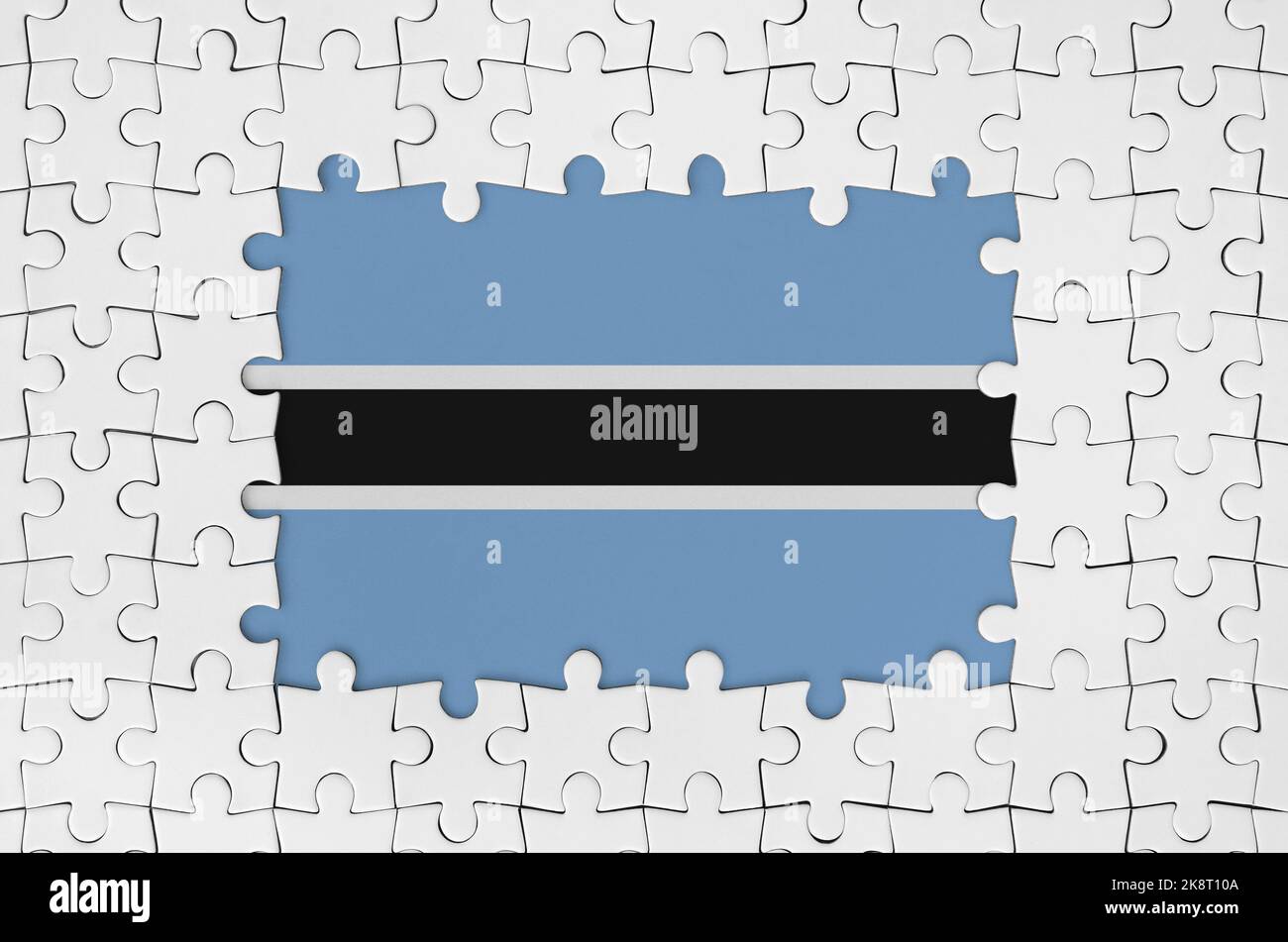 Botswana flag in frame of white puzzle pieces with missing central ...