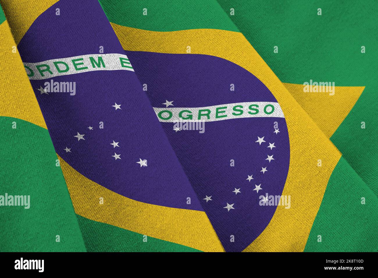 Brazil flag with big folds waving close up under the studio light ...