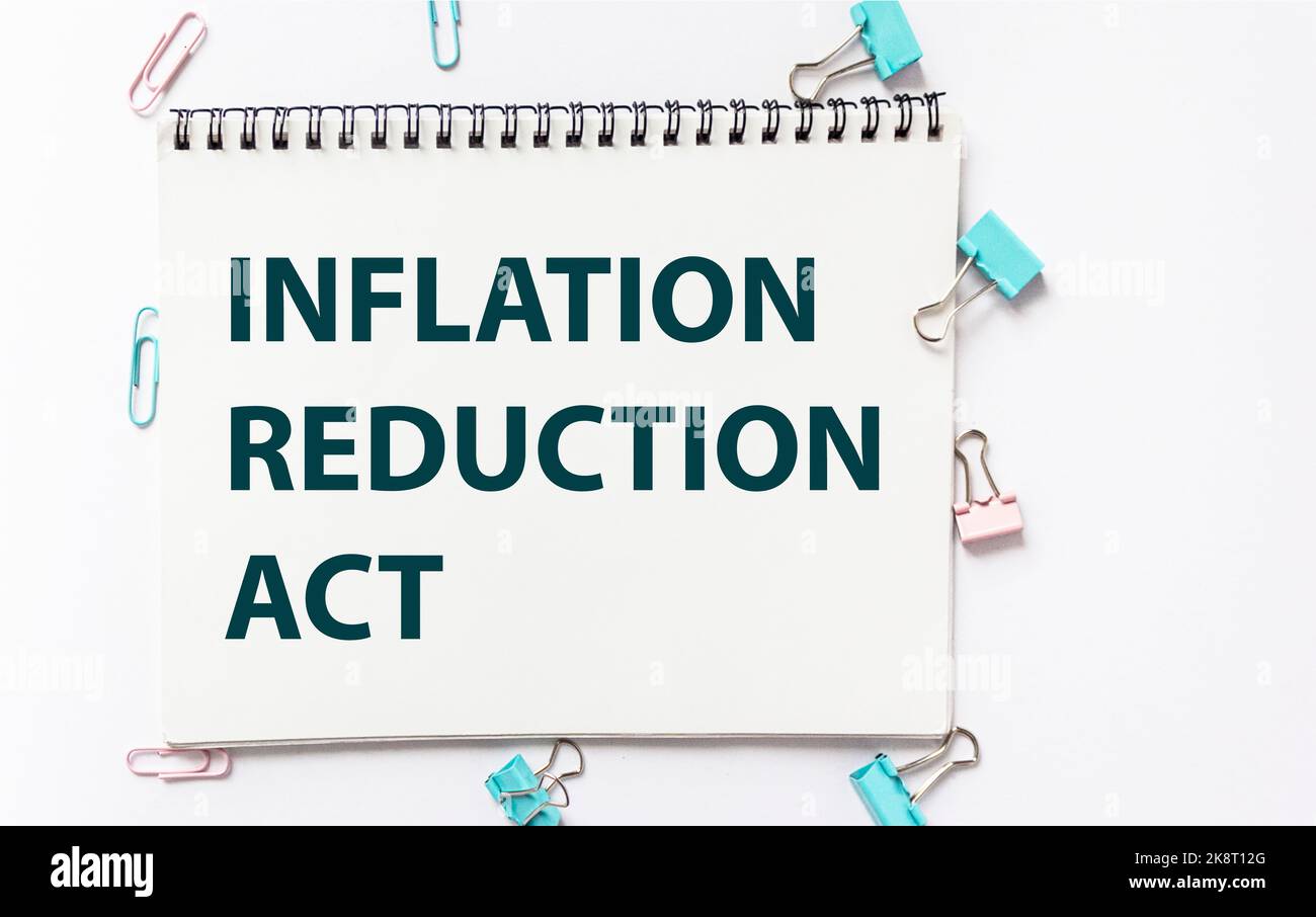 The text of the Inflation Reduction Act on a notebook, next to it are ...