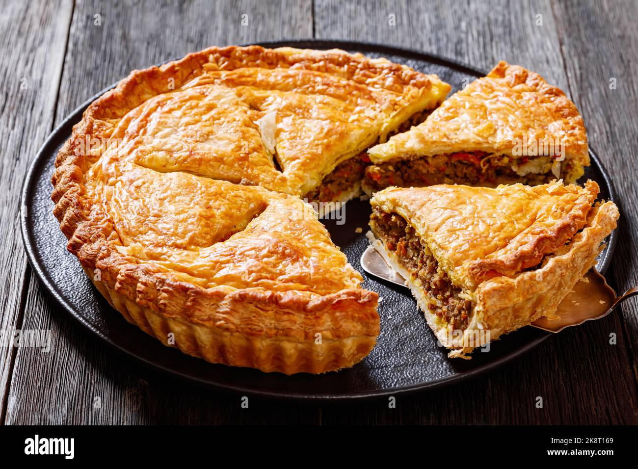 sliced Ground Beef Meat Pie with a flaky puff pastry double crust with ...