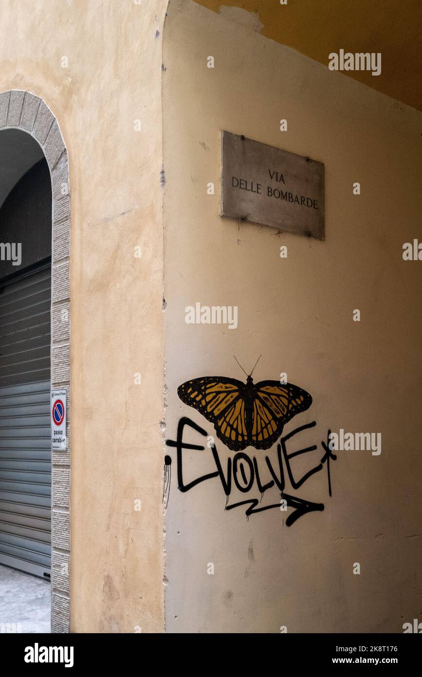 A vertical shot of graffiti art on a street corner building depicting a ...