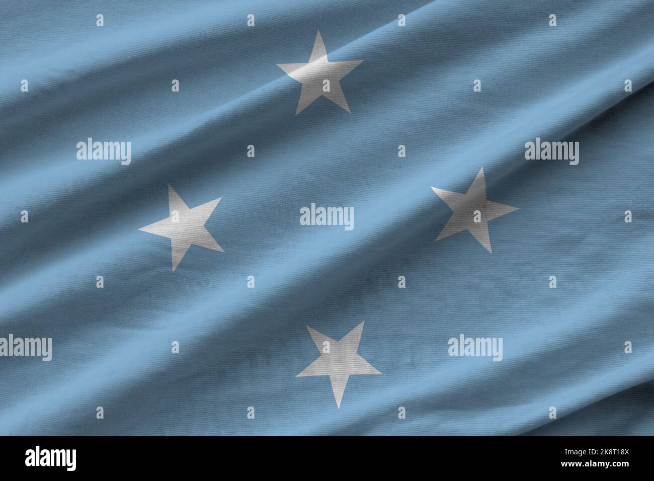 Micronesia flag with big folds waving close up under the studio light ...