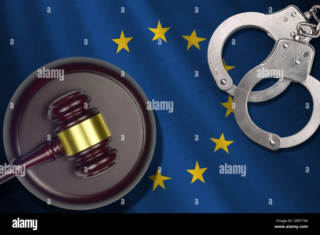 European union flag with judge mallet and handcuffs in dark room ...