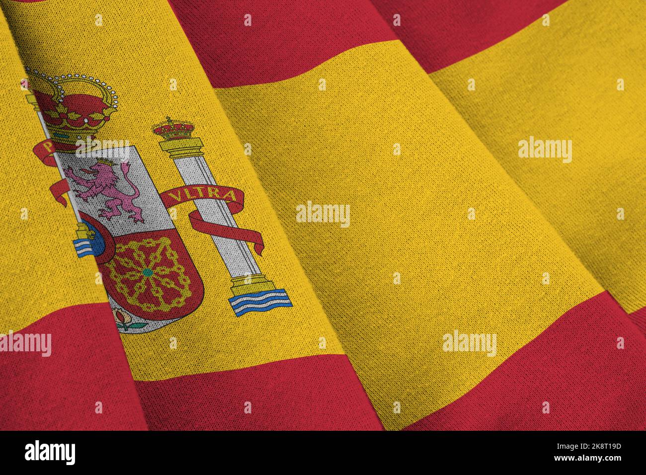Spain flag with big folds waving close up under the studio light ...