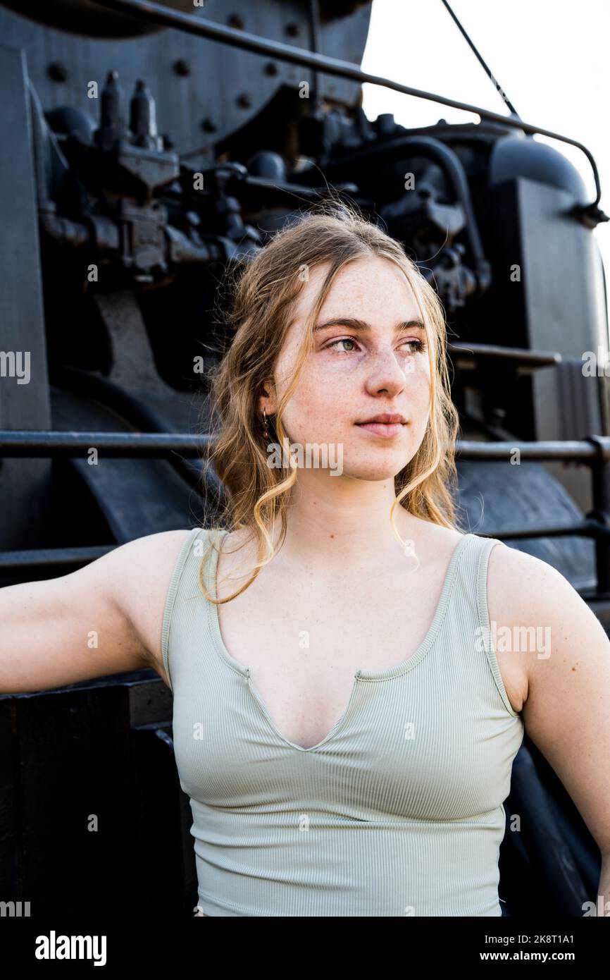 Teenage Girl in Trainyard Standing in Front of Old Black Steam Engine ...
