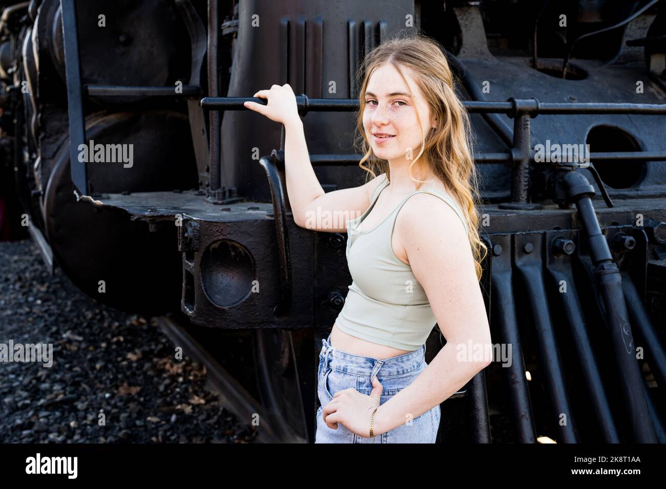 Teenage Girl in Trainyard Standing in Front of Old Black Steam Engine ...