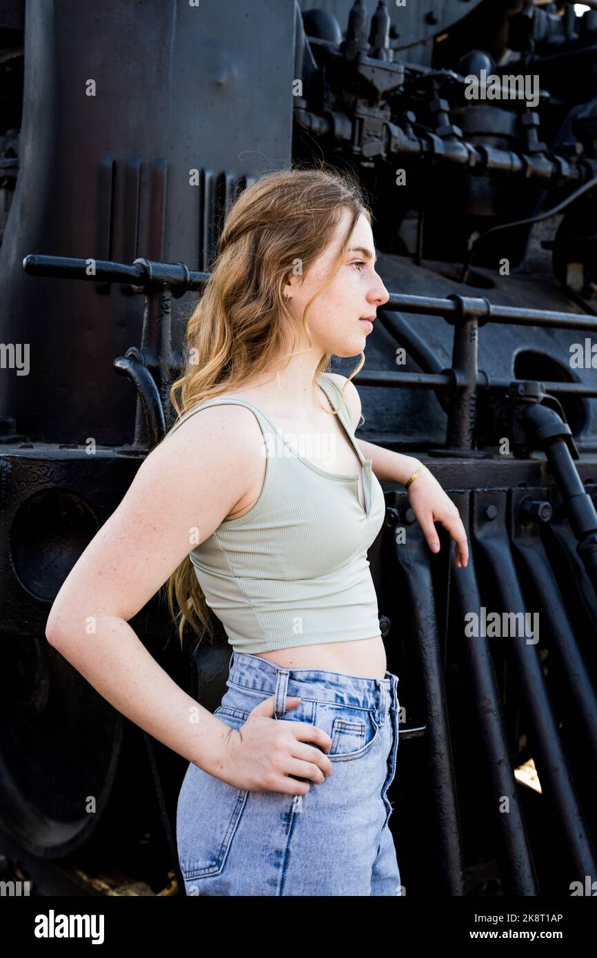 Teenage Girl in Trainyard Standing in Front of Old Black Steam Engine ...