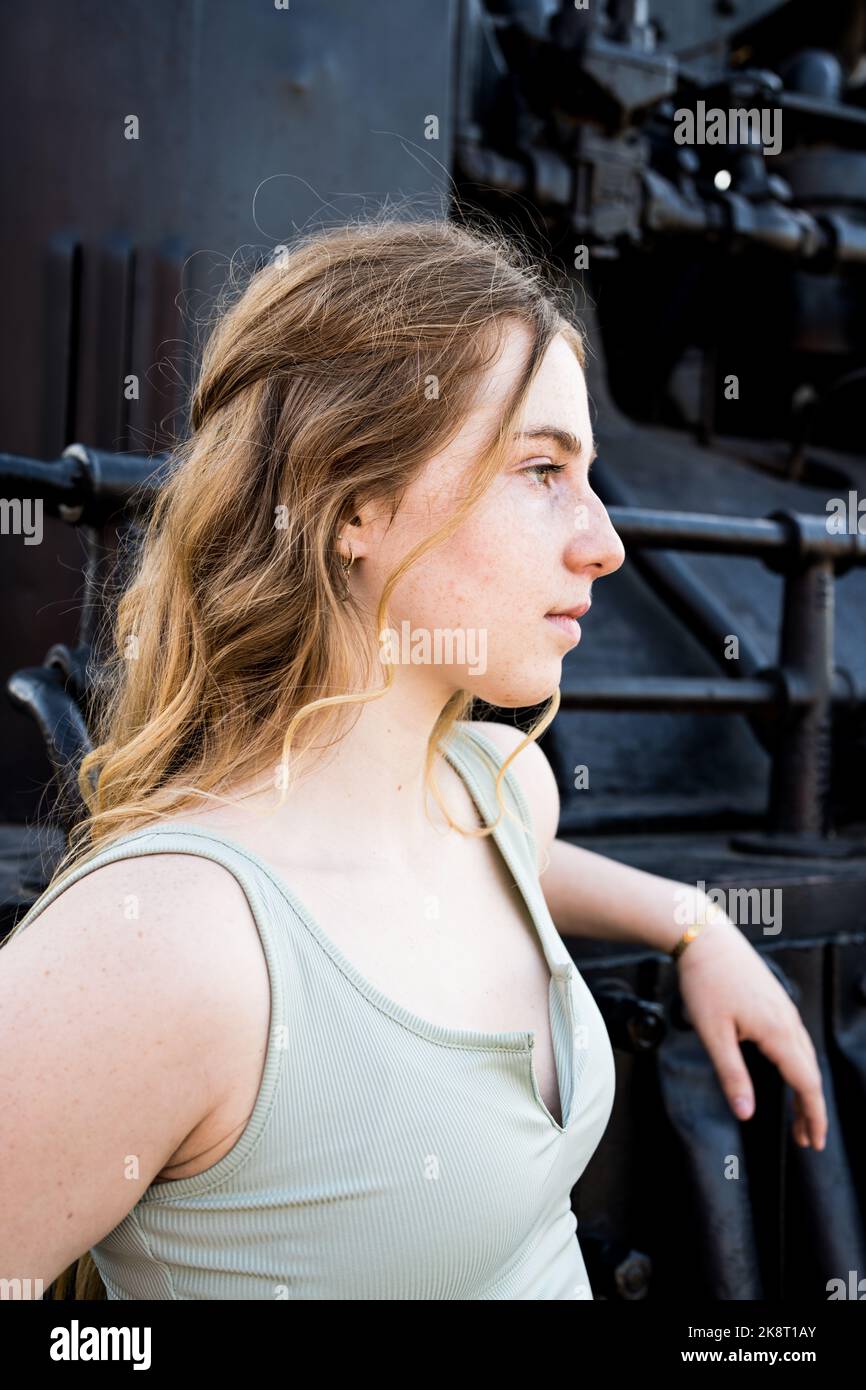 Teenage Girl in Trainyard Standing in Front of Old Black Steam Engine ...