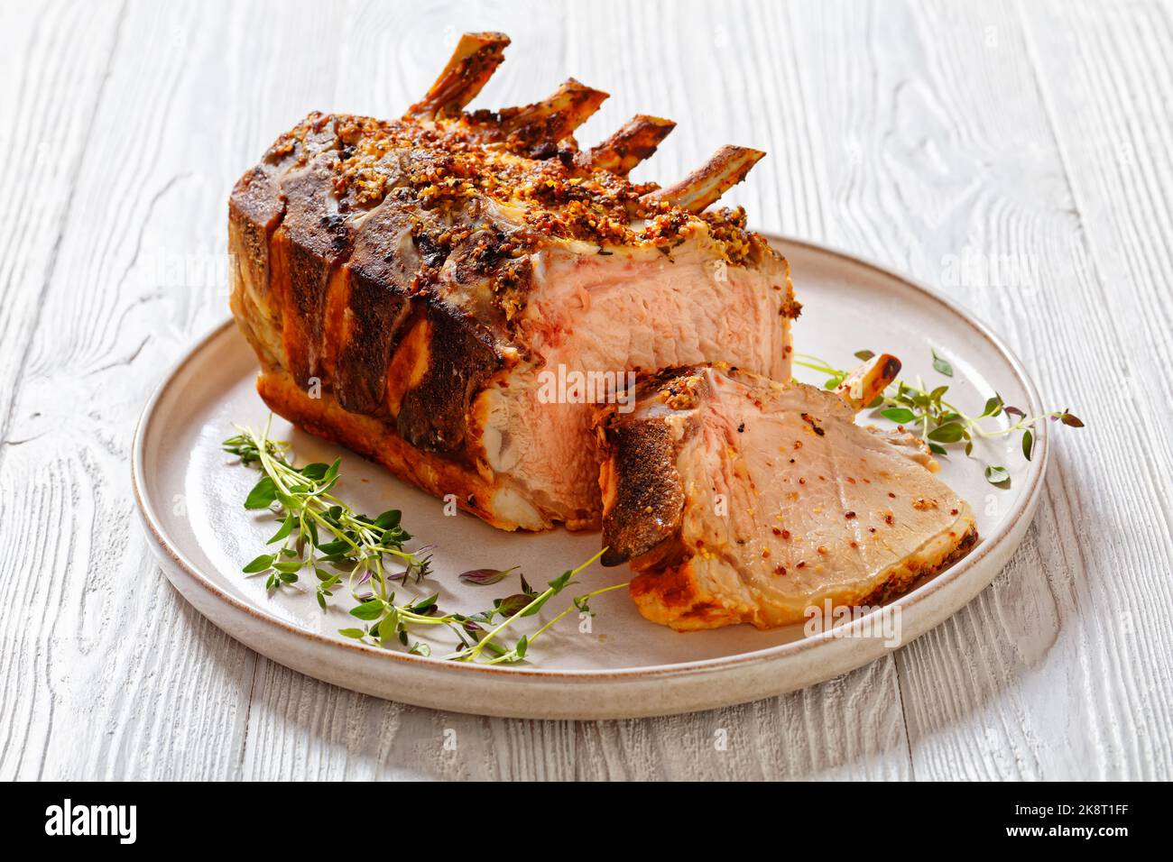 Standing Pork Rib Roast cut on chops with tomato sauce, mustard and ...