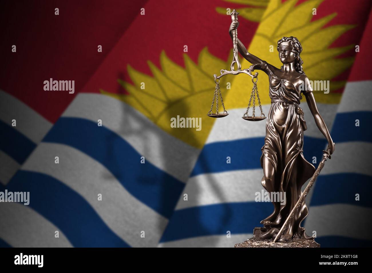 Kiribati flag with statue of lady justice and judicial scales in dark ...