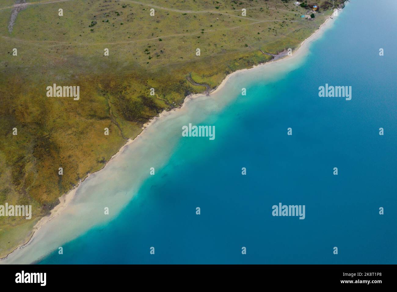 A aerial shot of azure ocean water rinse the coastline of Rara National ...