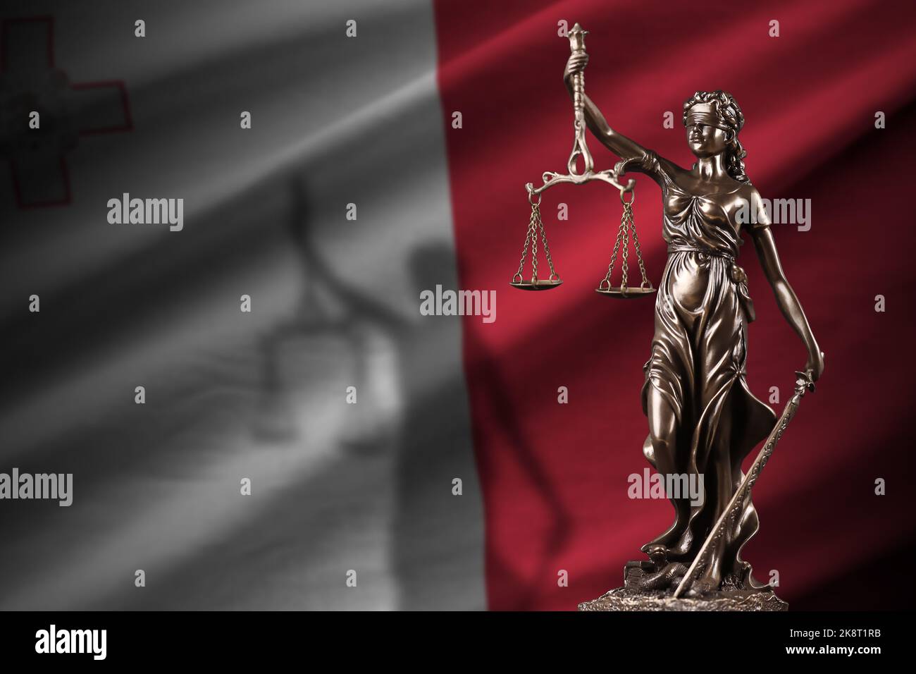 Malta flag with statue of lady justice and judicial scales in dark room ...
